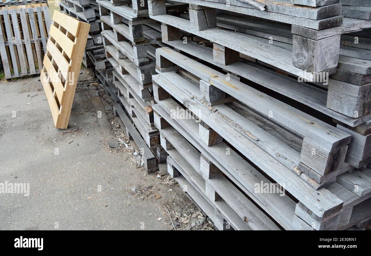 stacked wooden pallets. Wooden production pallets stand piled in a pile ...