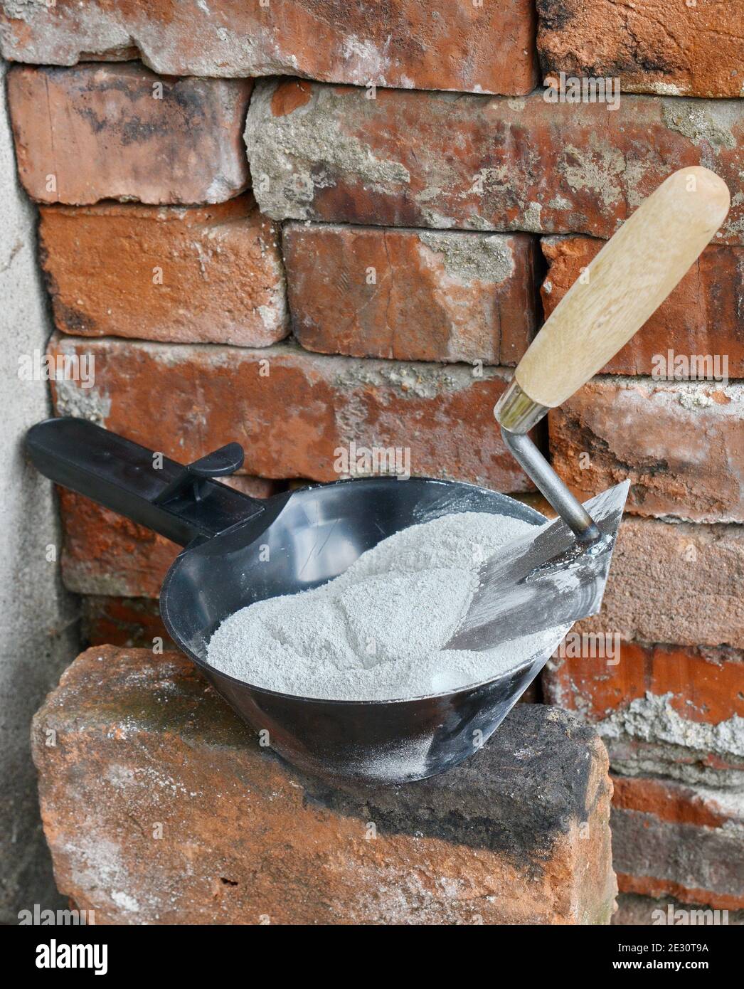 Cement or mortar powder with a trowel put on the brick for construction ...