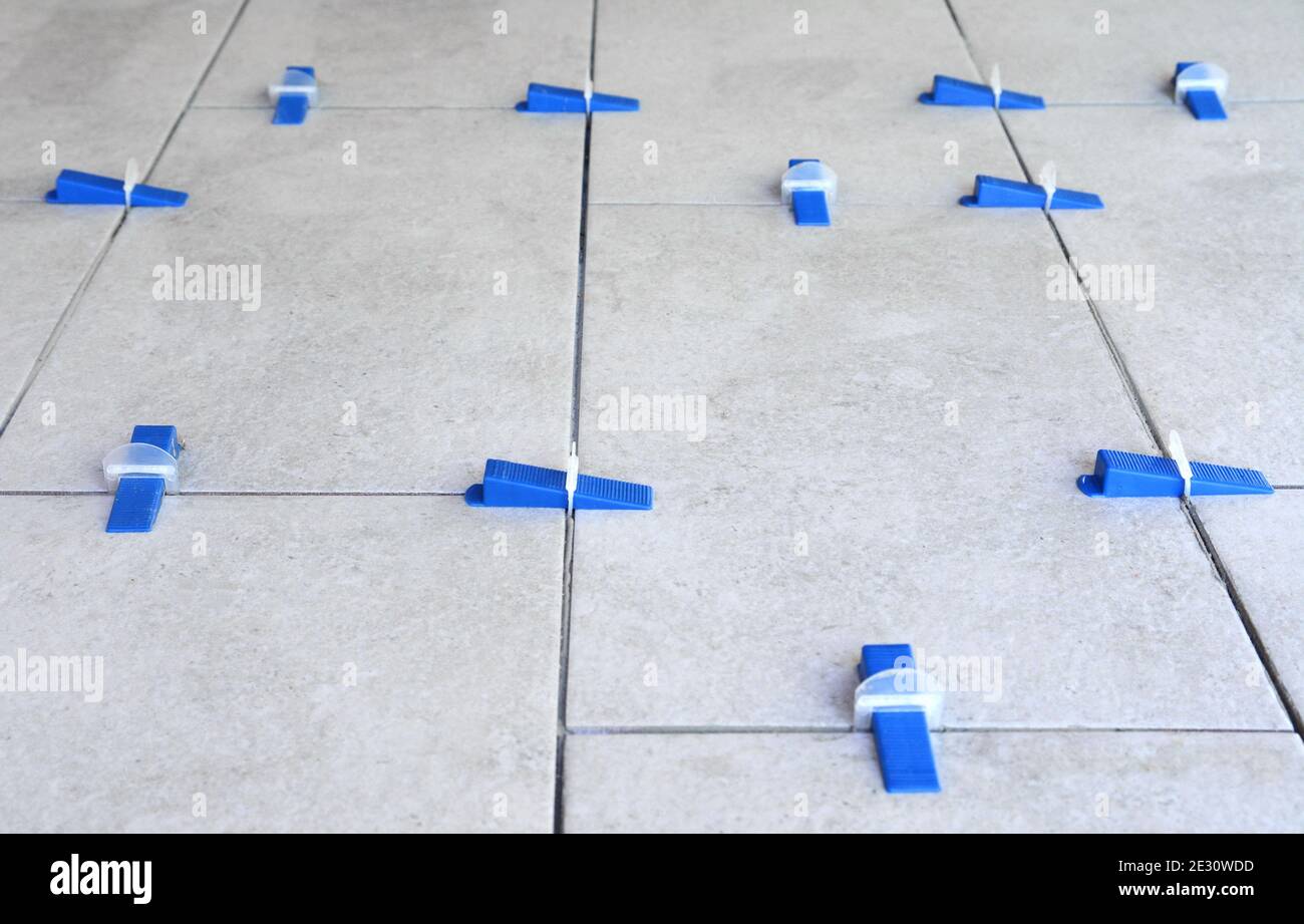 Tile leveling system with plastic clips and wedges, shot while the tile ...
