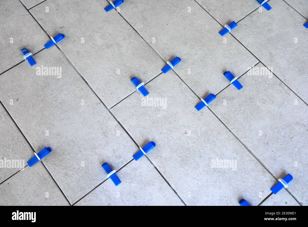 Tile leveling system with plastic clips and wedges, shot while the tile ...