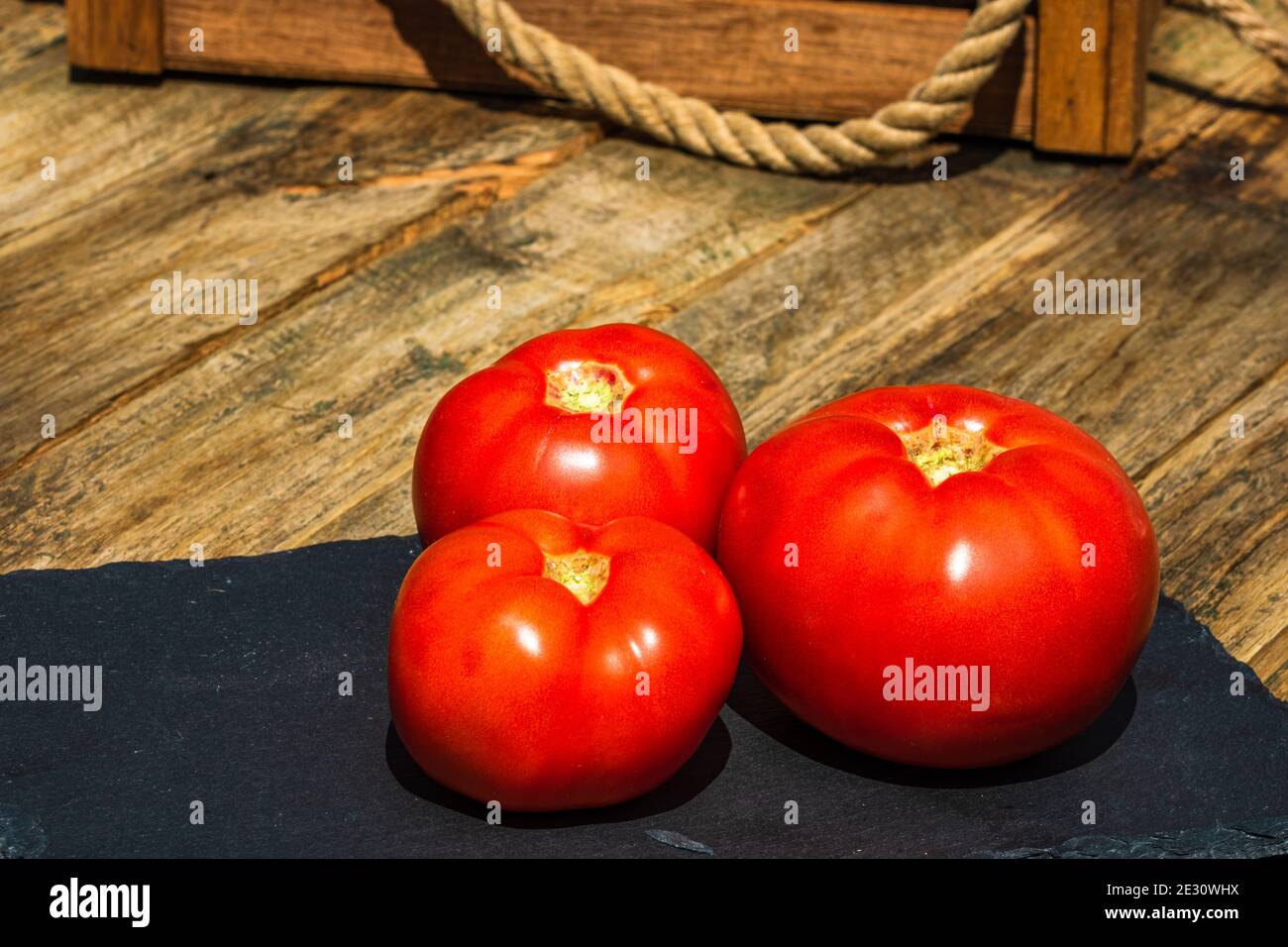 Close up of fresh ripe tomatoes isolated in a rustic composition Stock ...