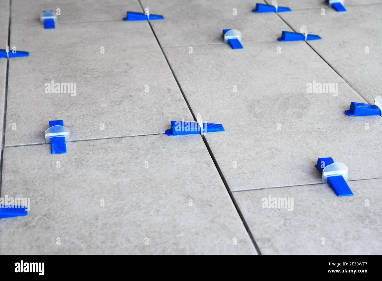 Tile leveling system with plastic clips and wedges, shot while the tile ...