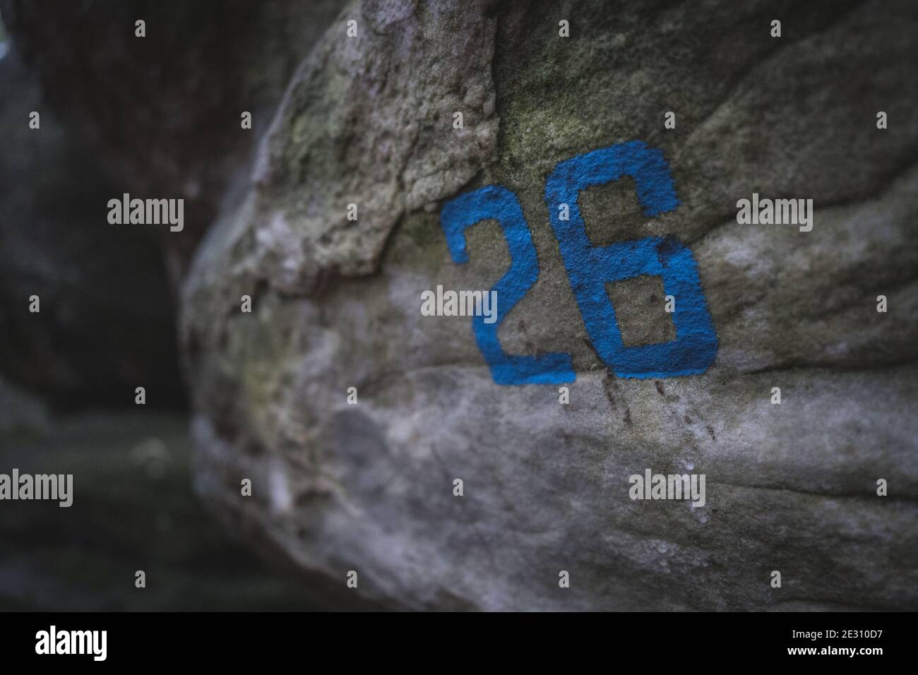 The number 26 painted in blue to mark a boulder problem in ...