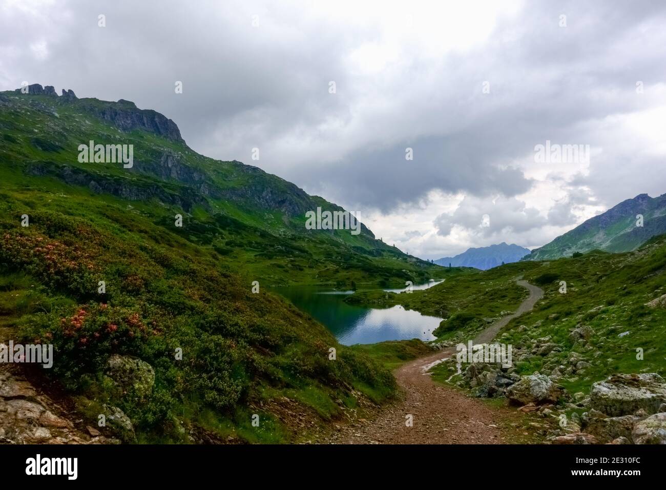 path around a beautiful clear mountain lake while hiking in the summer ...