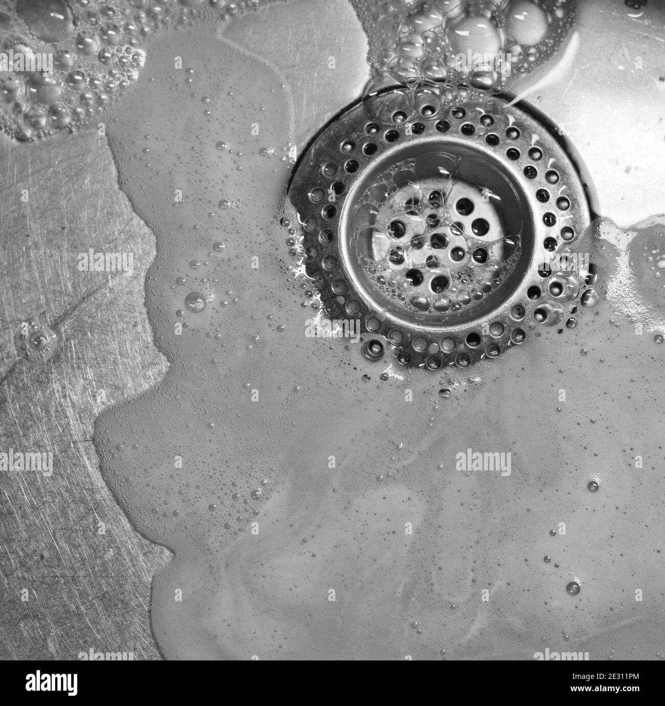 Water and foam flowing down hole in kitchen sink Stock Photo - Alamy