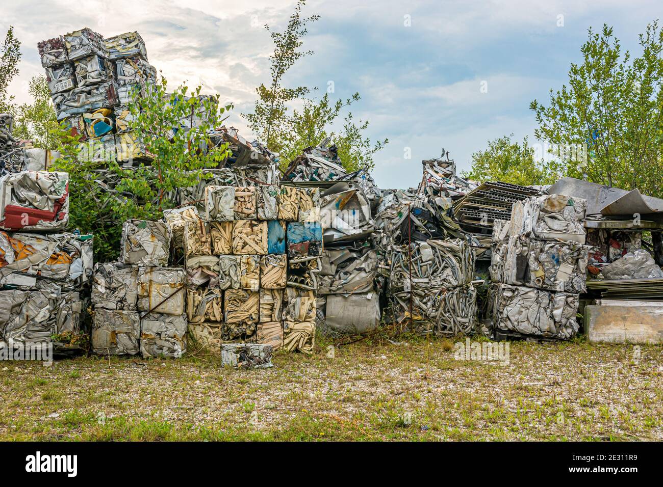 Compressed aluminium scrap in large cubes forming landfill in piles ...