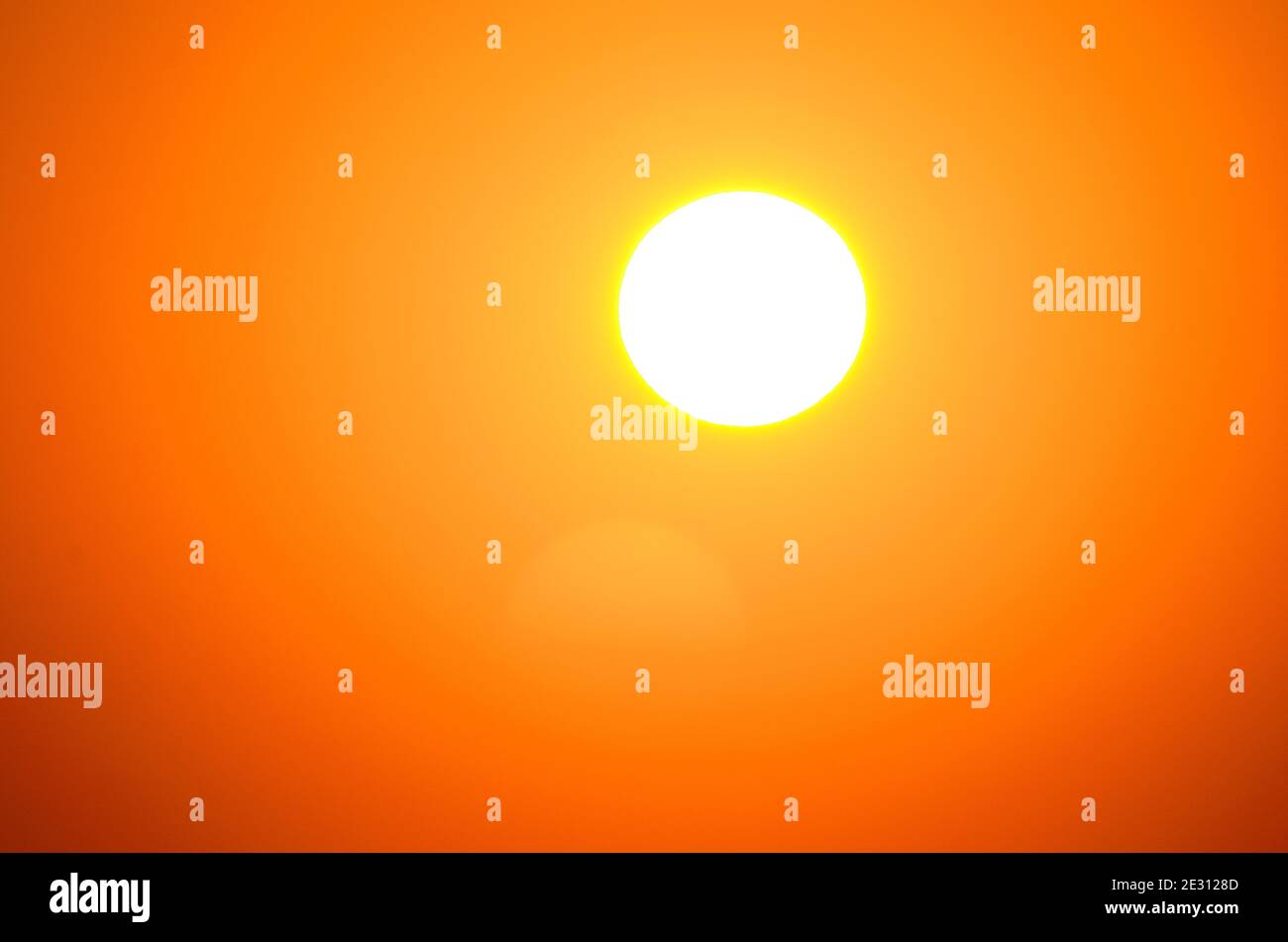 very bright sun and warm orange sky at sunrise Stock Photo - Alamy