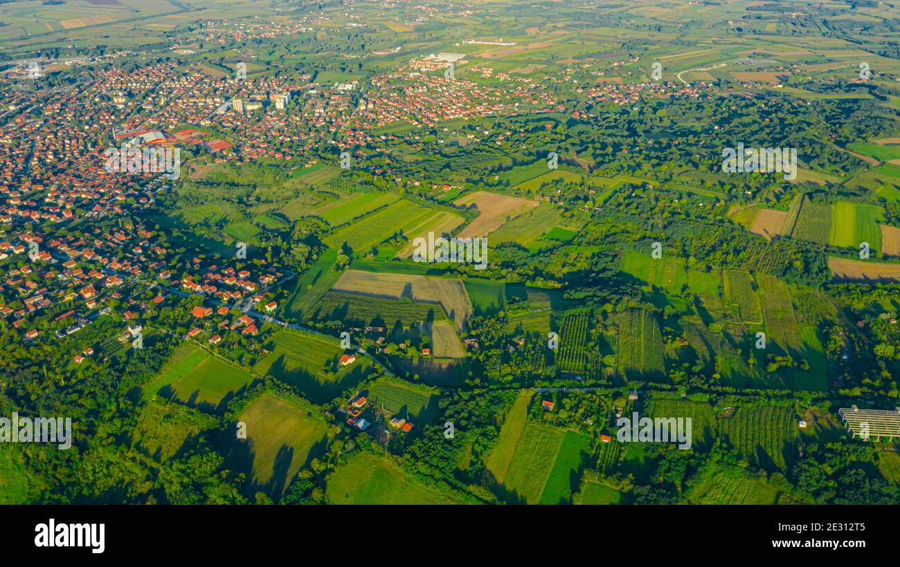 Shot above over green hilly landscape, several cultivated plots among ...