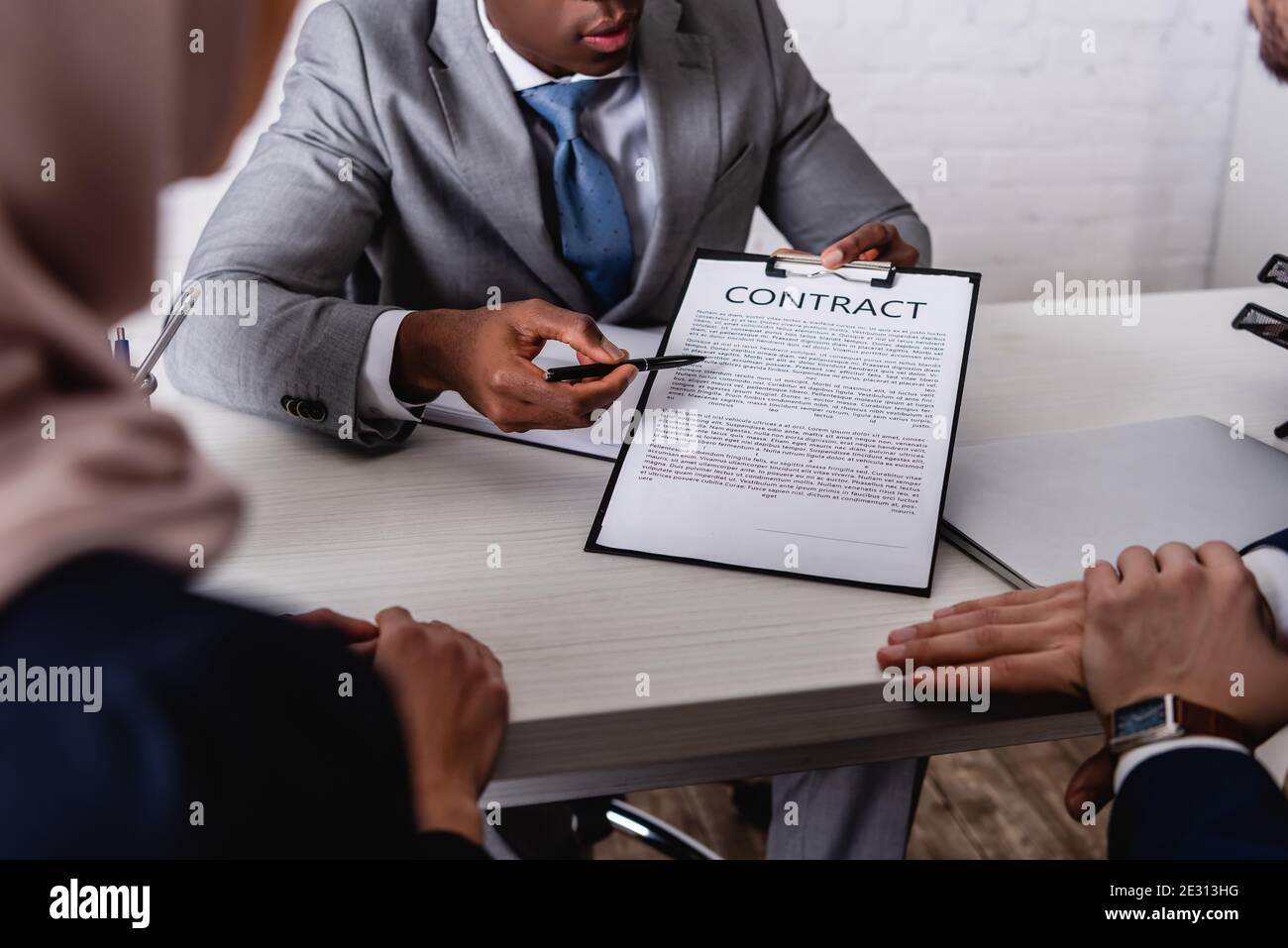partial view of african american businessman pointing at contract ...