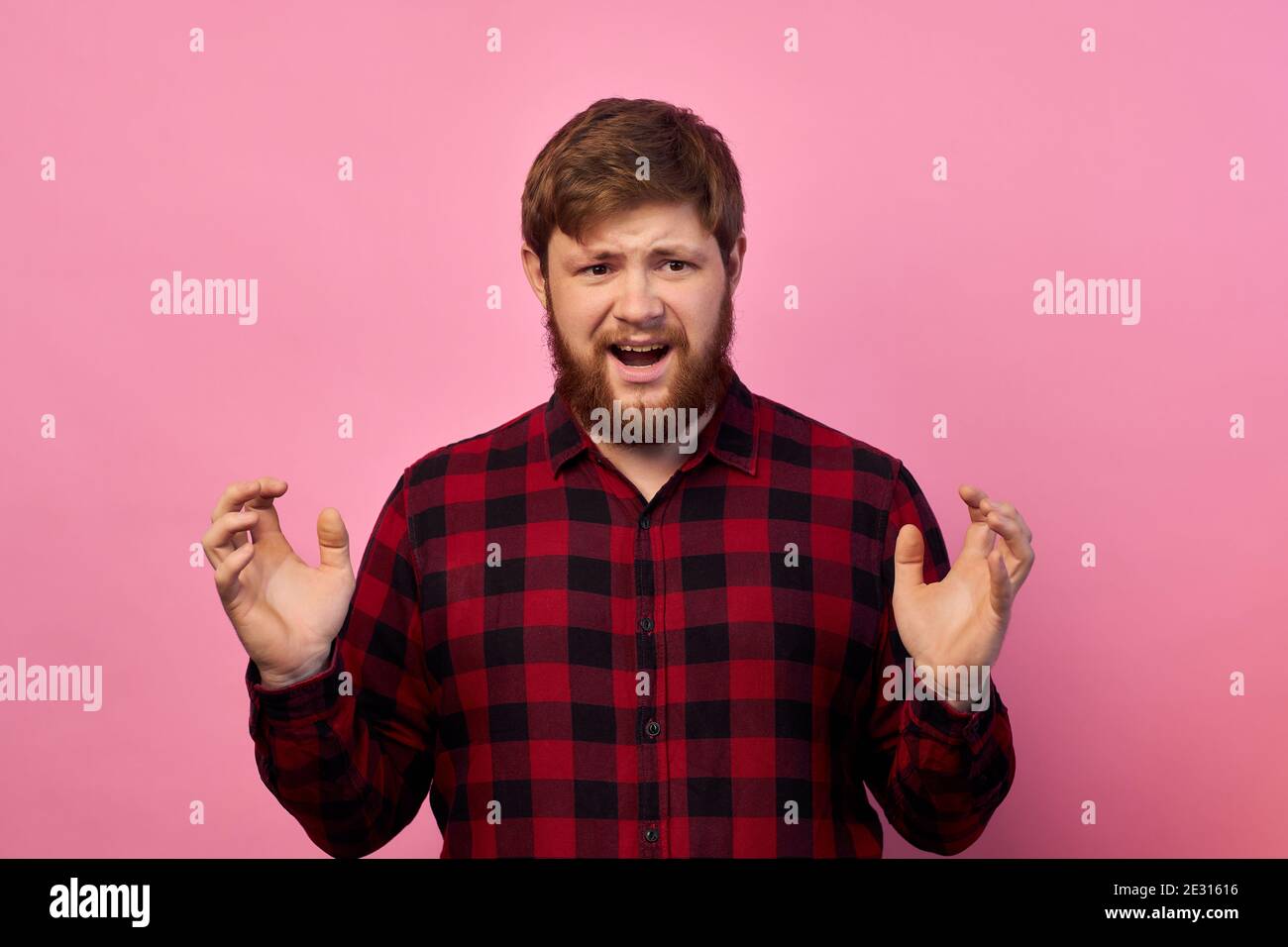 Shocked embarrassed young man demonstrates something very huge, gasps ...