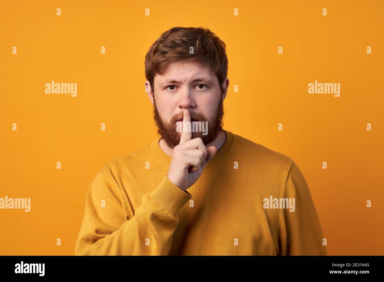Photo of secret ginger stylish male guy shows silence sign, has ...