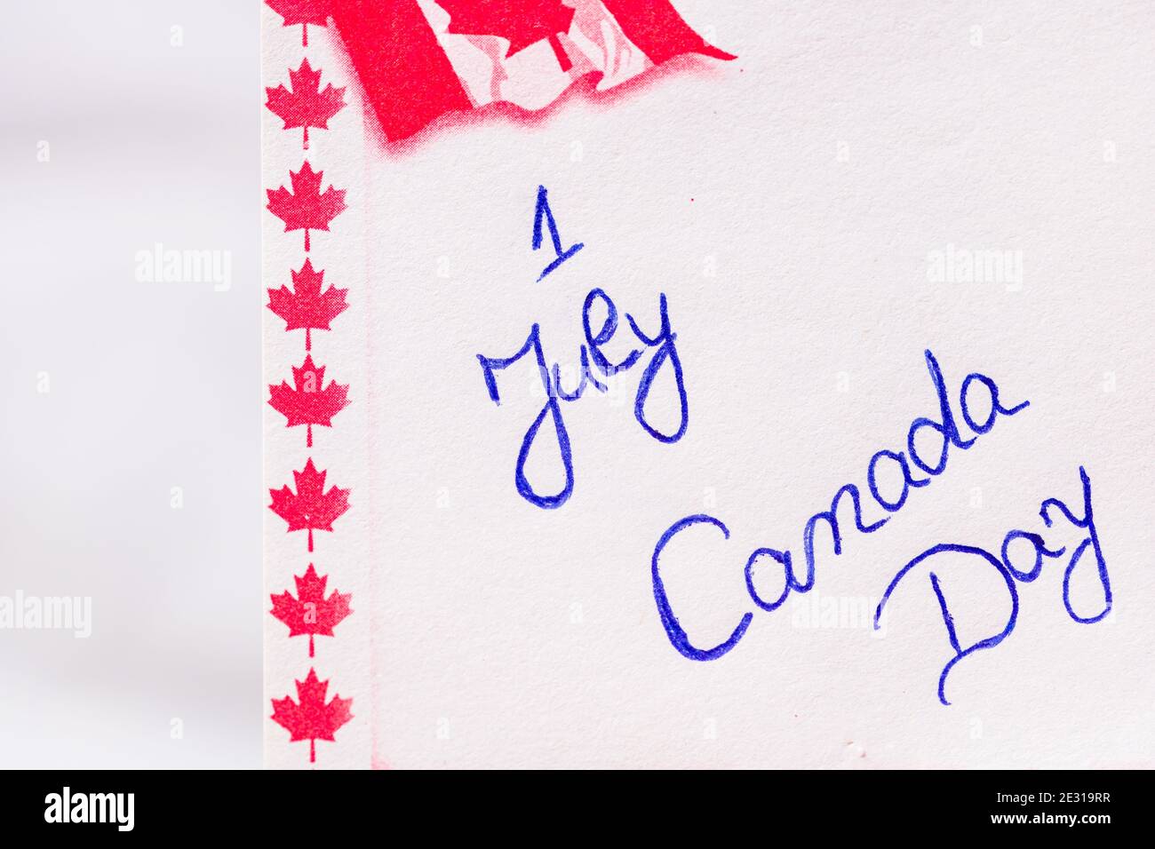 Canada day 1 July handwriting on paper with Canada flag. Writing text ...