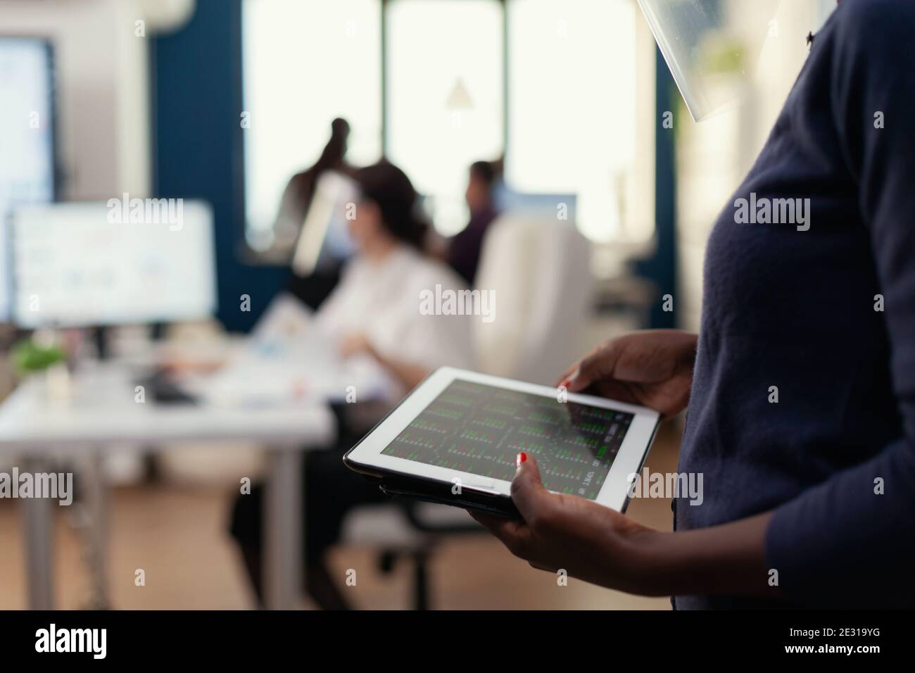 African businesswoman checking corporate graph on tablet pc ...