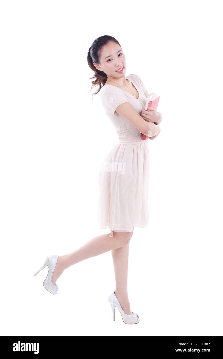 A Young woman standing, hugging a book high quality photo Stock Photo ...