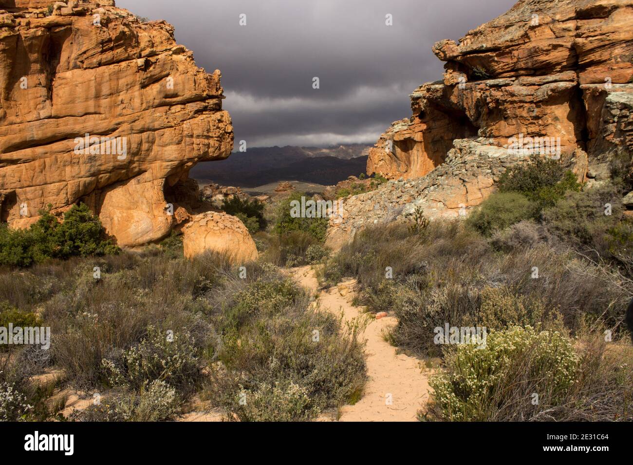 A small trail leading through a natural gateway between two large ...