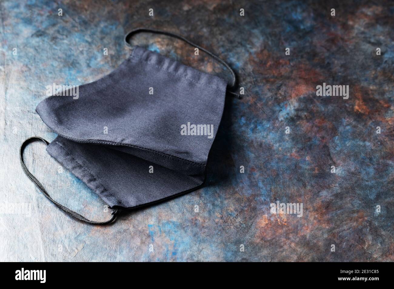 Handmade black protective mask on a dark background. Antivirus reusable ...
