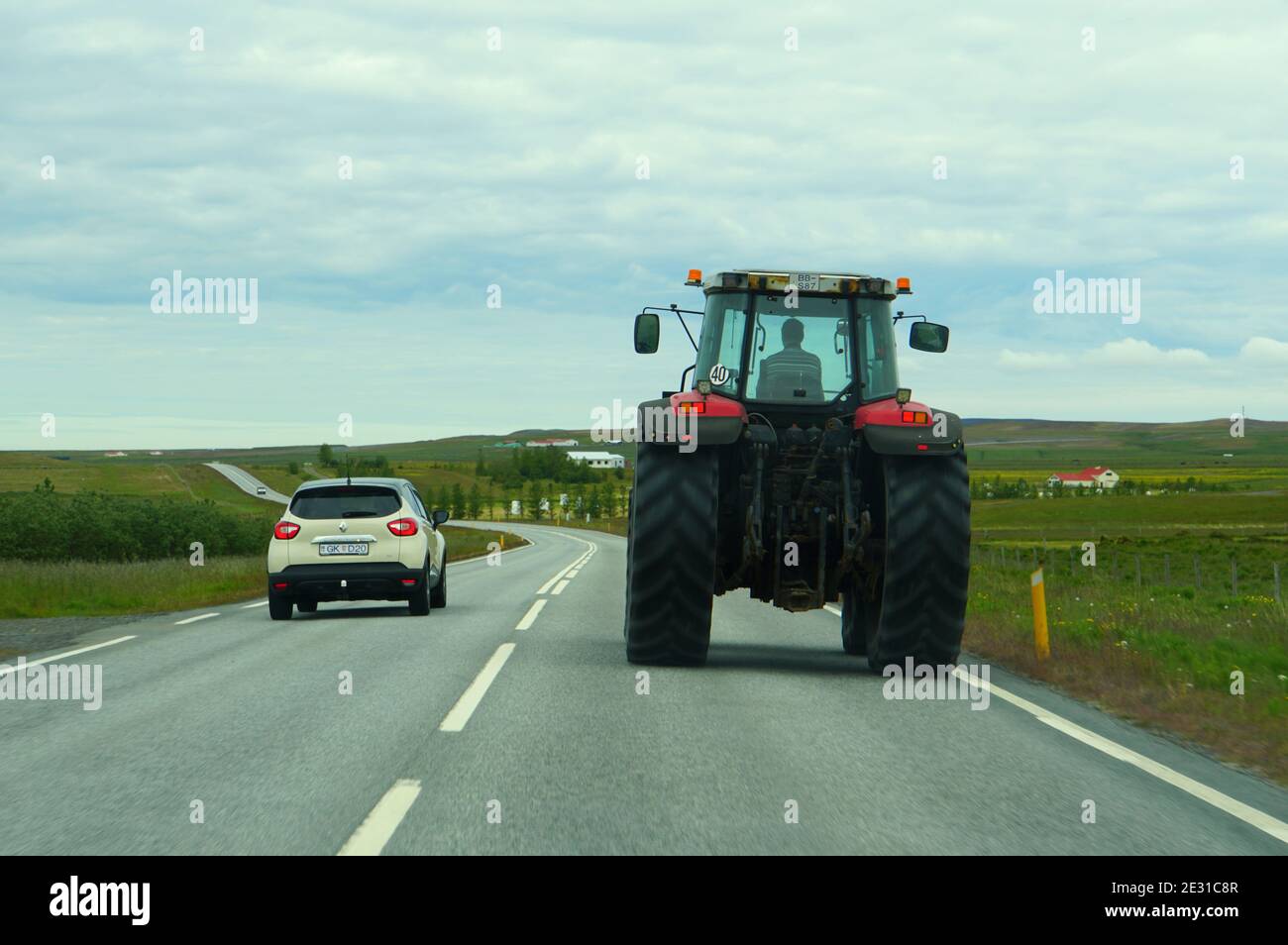 Reykjavik, Iceland - June 23, 2019 - A small car passing a big tractor ...