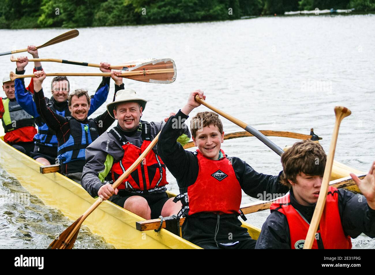 Mixed team of children and adults paddling V6 Hawaiian outrigger canoes ...
