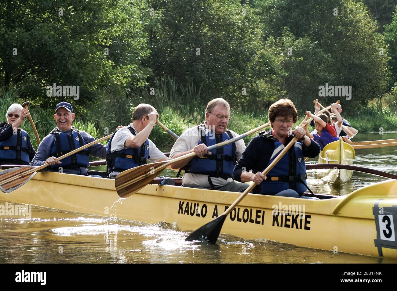 Actove elderly people smiling and having fun paddling a V6 Hawaiian ...