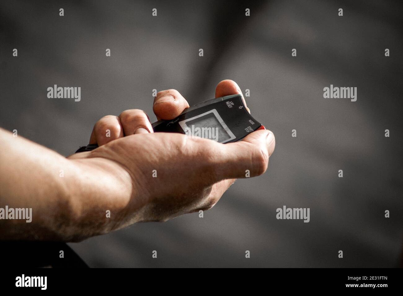A man's hand holding a digital stopwatch Stock Photo - Alamy
