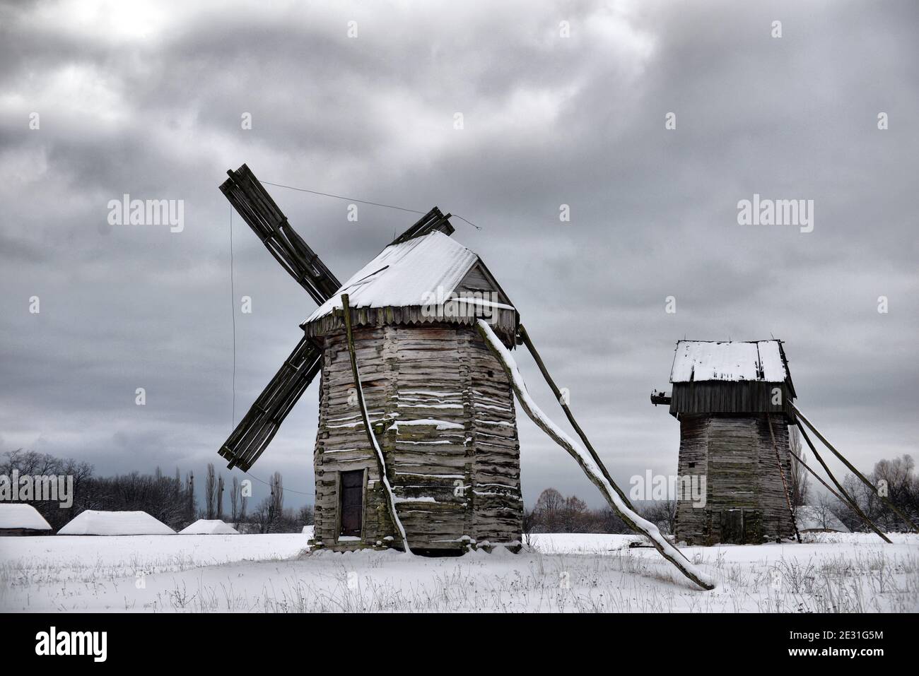 Antique wooden windmill in snowy ukrainian village. Winter landscape ...