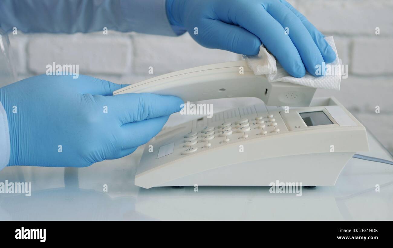 Image with Hands Wearing Protective Gloves Cleaning a Telephone with a ...
