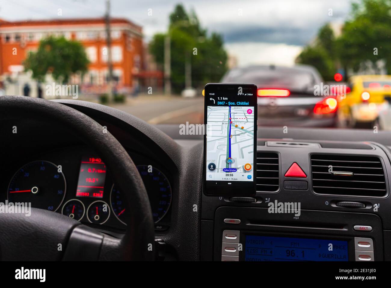 Driving and using waze maps application on smartphone on car dashboard ...