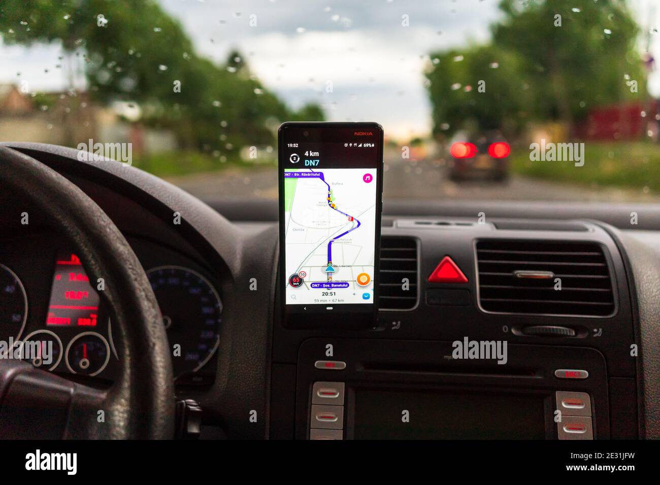 Driving and using waze maps application on smartphone on car dashboard ...