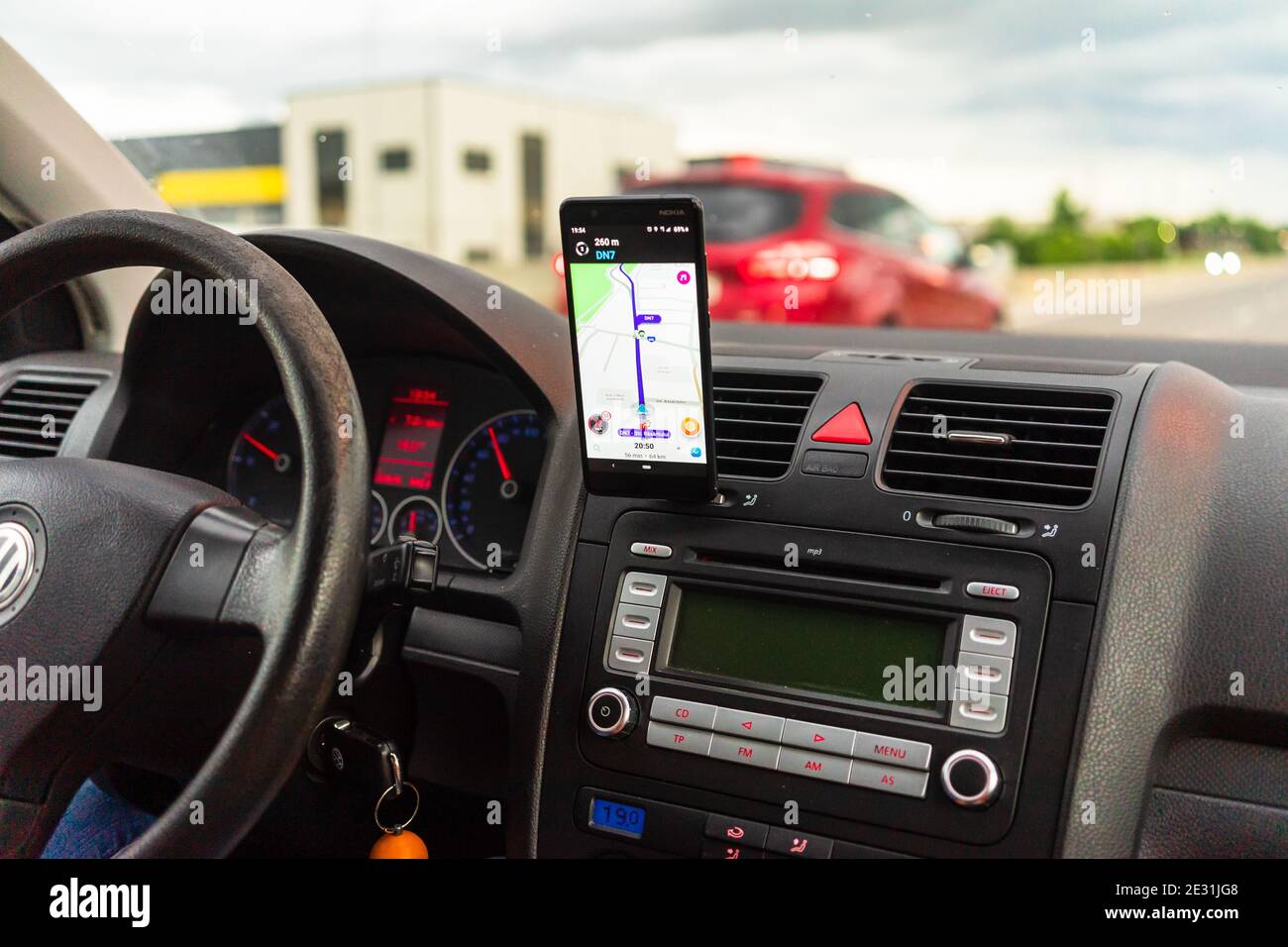 Driving and using waze maps application on smartphone on car dashboard ...
