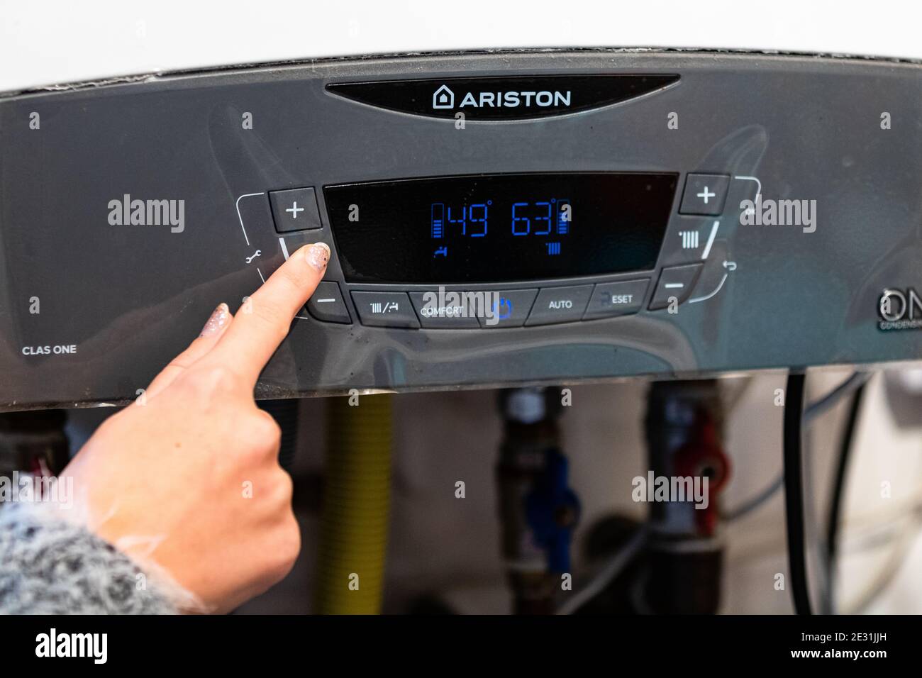 Girl hand setting temperature to heating system. Central heating ...