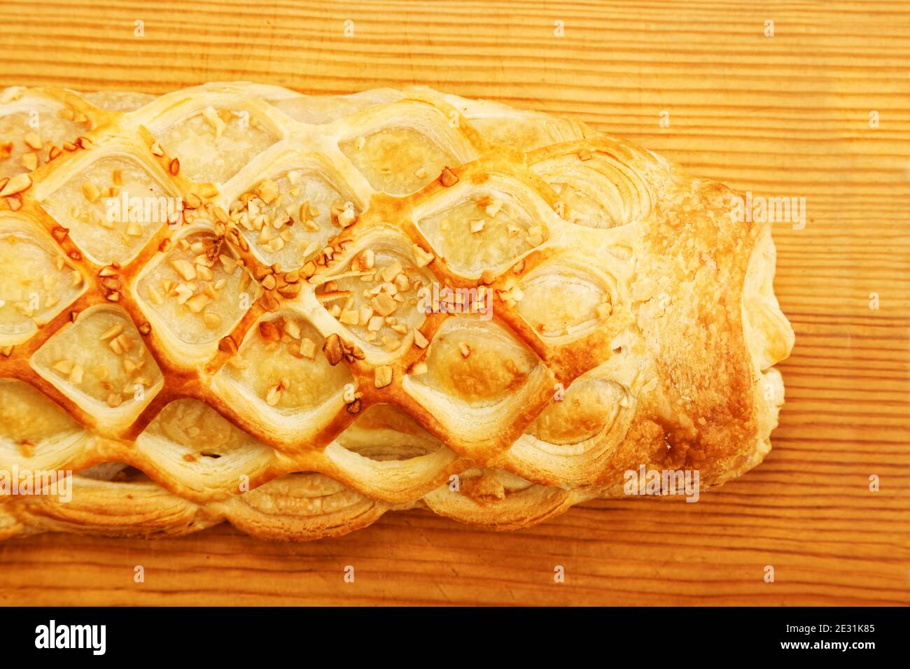 Closeup homemade cherry strudel sprinkled with crushed nuts lying on ...