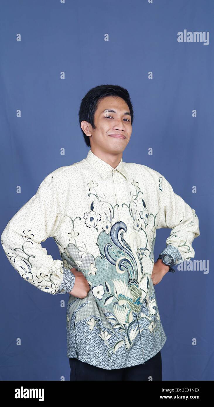 asian man stylish with batik clothes in studio isolated with blue ...
