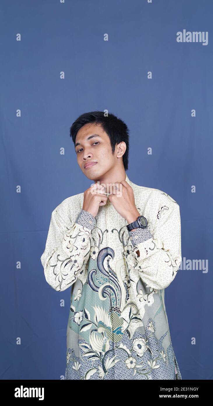 asian man stylish with batik clothes in studio isolated with blue ...