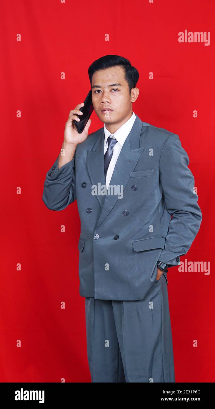 Business asian man calling isolated red background Stock Photo - Alamy