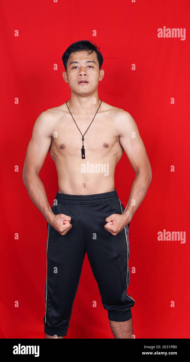 asian man bodybuilder isolated red background Stock Photo - Alamy