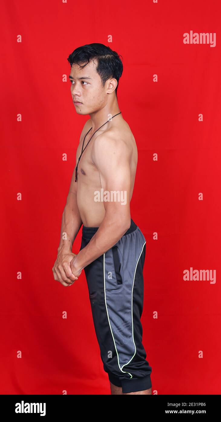 asian man bodybuilder isolated red background Stock Photo - Alamy