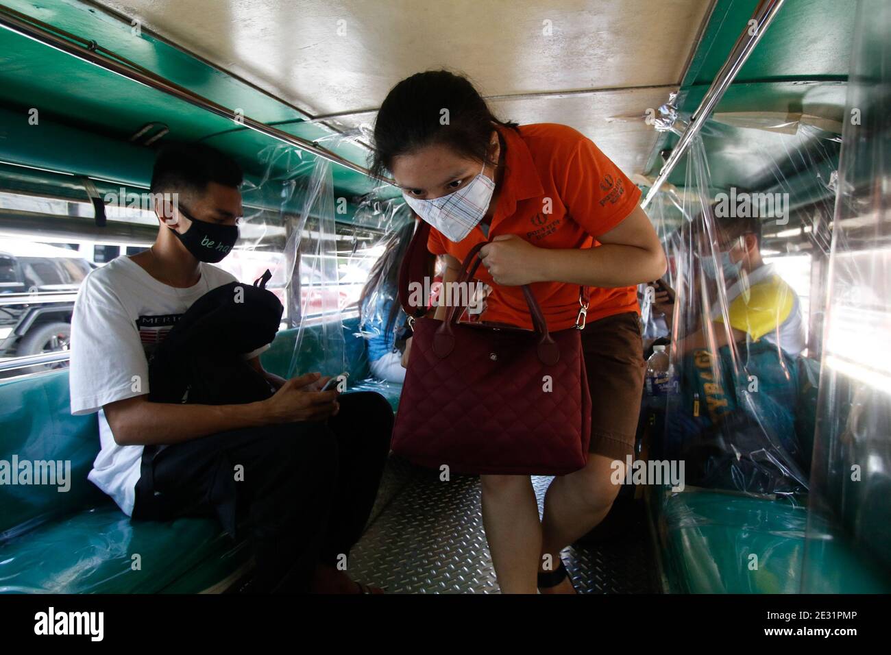 A passenger prepares to ride a modified traditional jeepney along ...