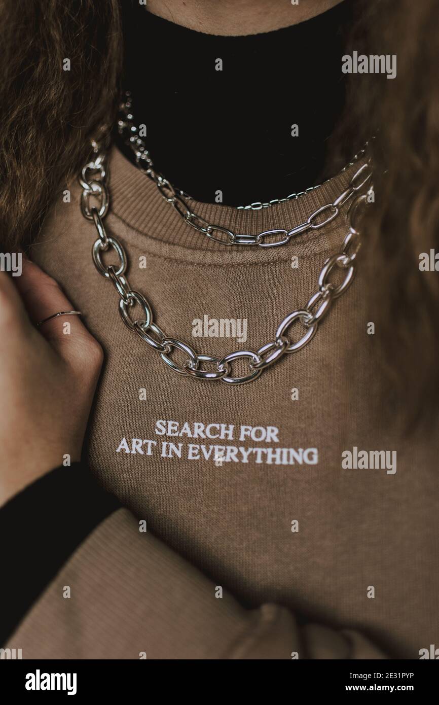 Closeup of a female wearing a thick chain necklace and a sweatshirt ...
