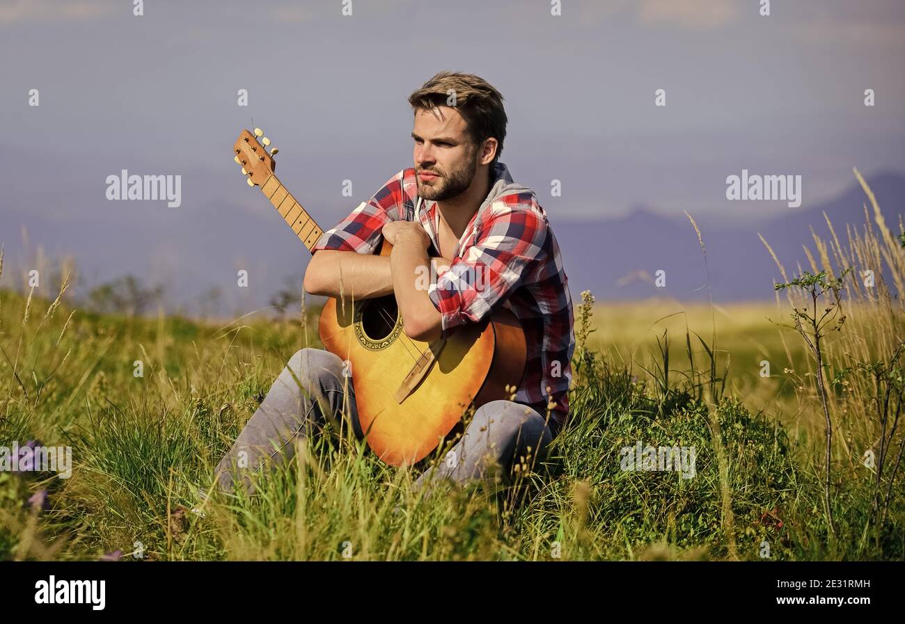 Pleasant time alone. Peaceful mood. Guy with guitar contemplate nature ...