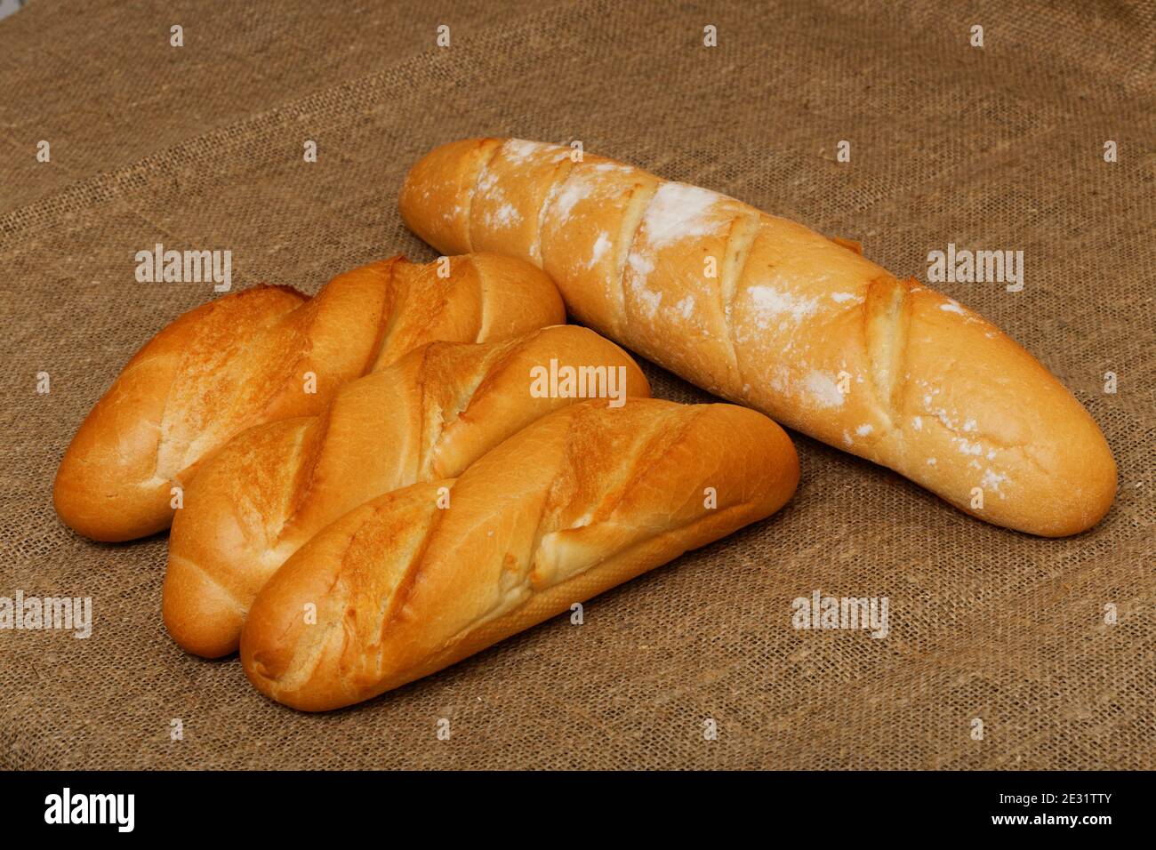 three small freshness loaf of bread and long baguette on the bagging ...