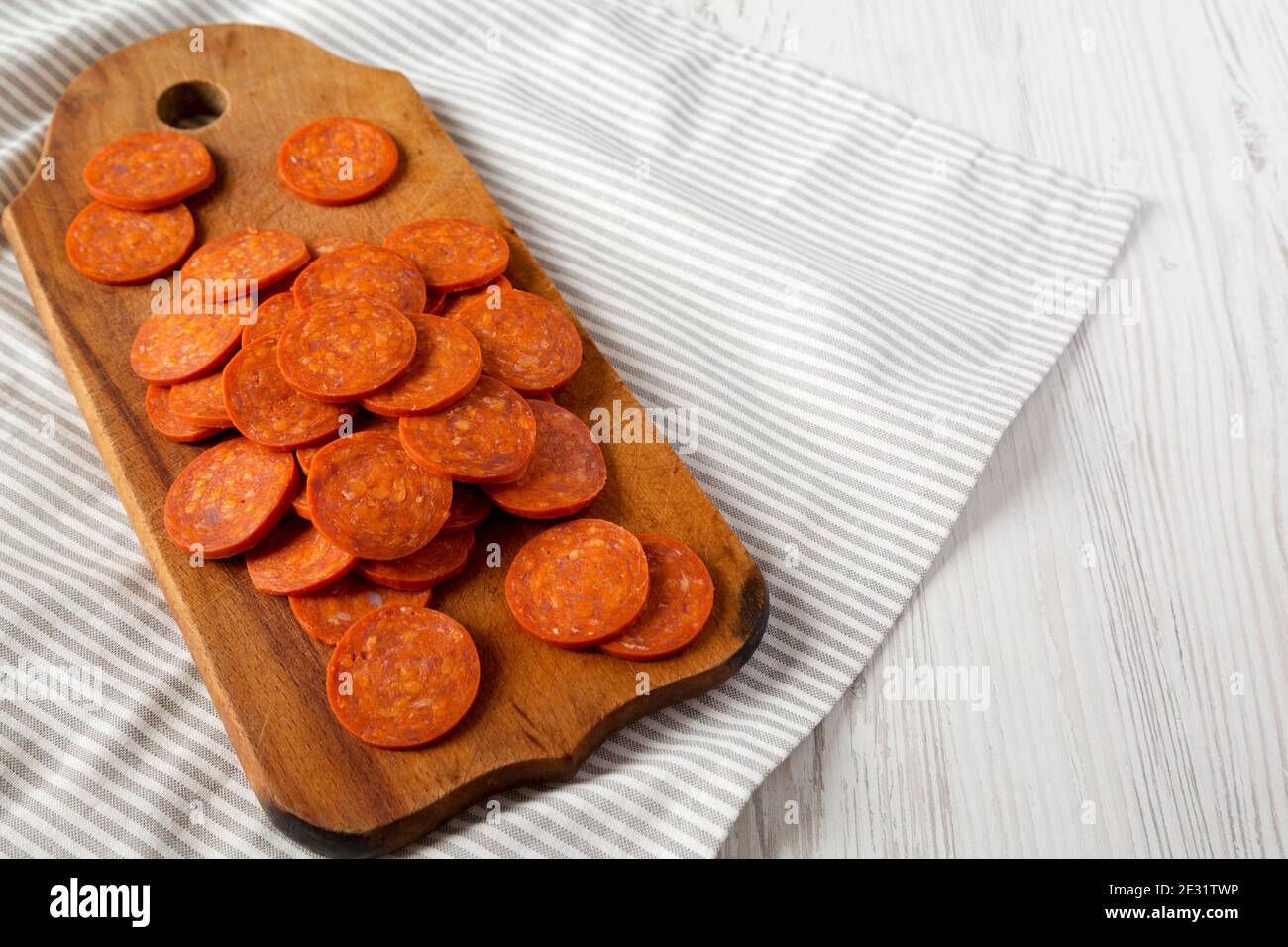 Italian Pepperoni Slices on a rustic wooden board on cloth, low angle ...