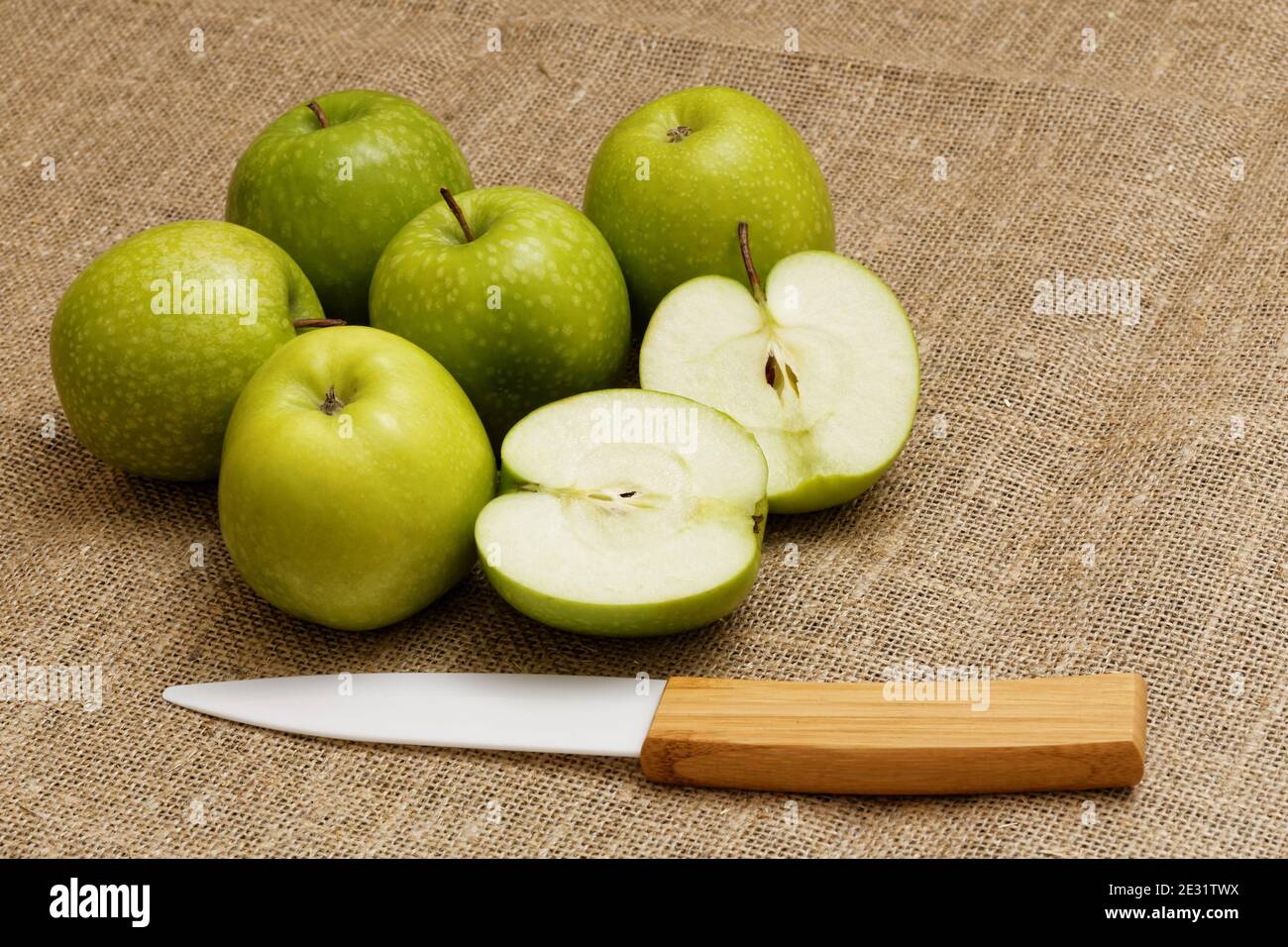 Six small green apple and ceramic knife on the bagging Stock Photo - Alamy
