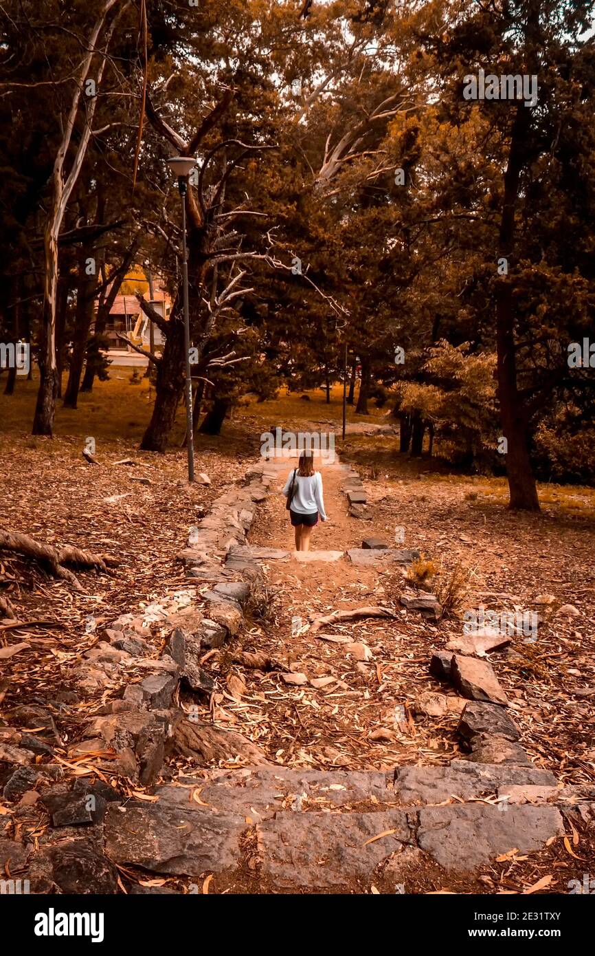 Young lady walking down in an old pathway with autumn leaves on the ...