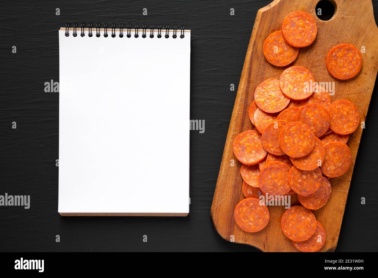 Italian Pepperoni Slices on a rustic wooden board, blank notepad, top ...