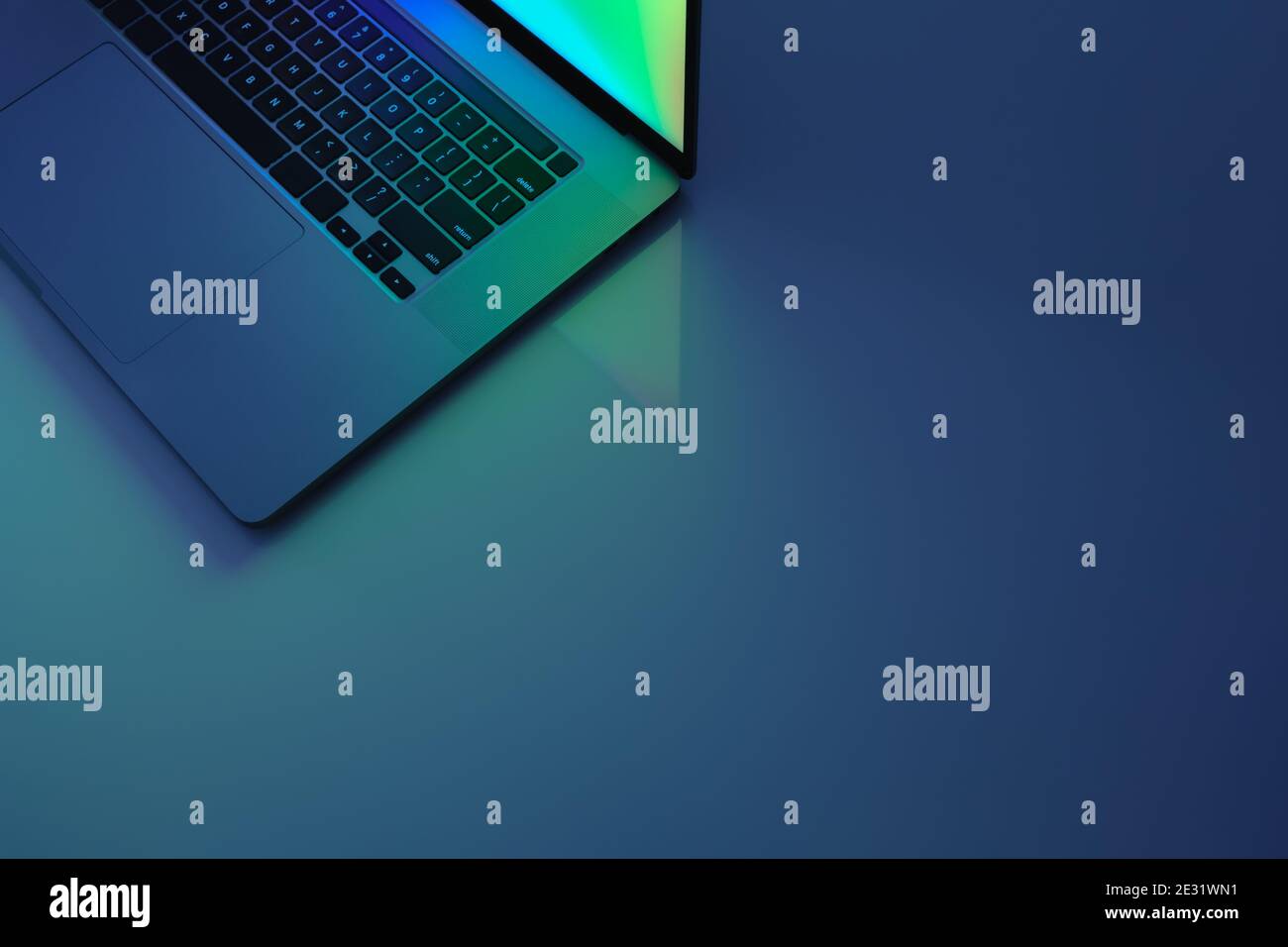 Laptop computer standing on a table, low key blue light image. Concept ...