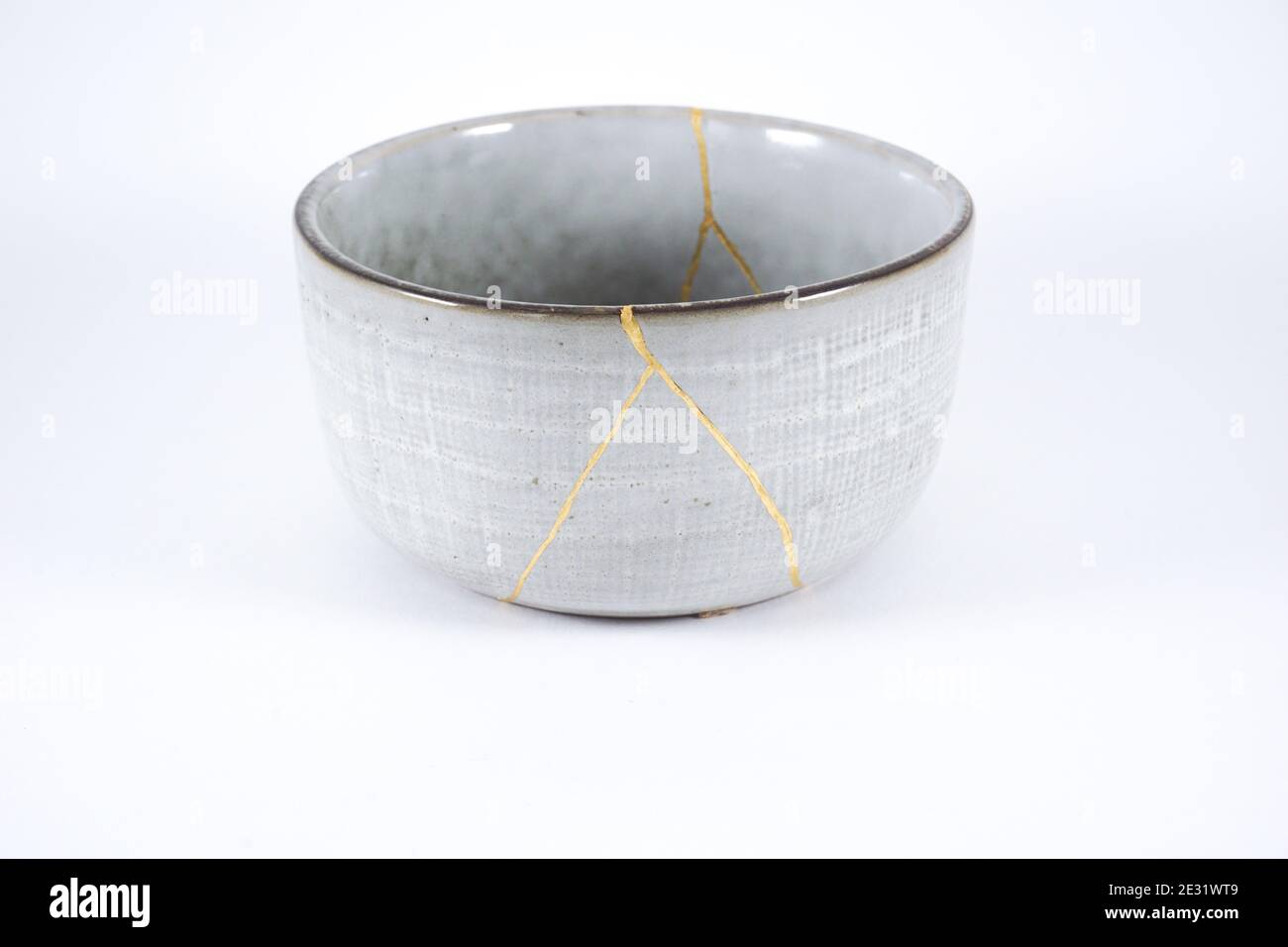 Kintsugi bowl, real gold restoration on grey pottery Stock Photo - Alamy