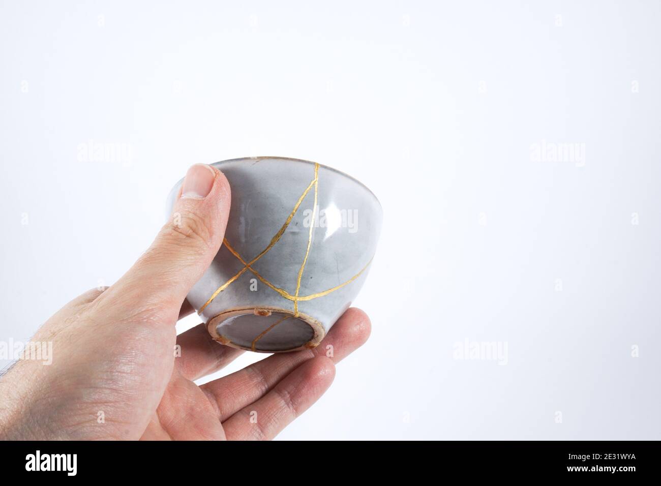 Kintsugi bowl, real gold restoration on grey pottery Stock Photo - Alamy