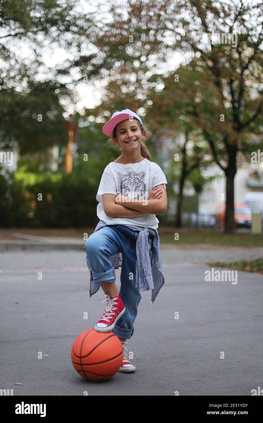 A portrait of a girl who put her foot on a basketball Stock Photo - Alamy