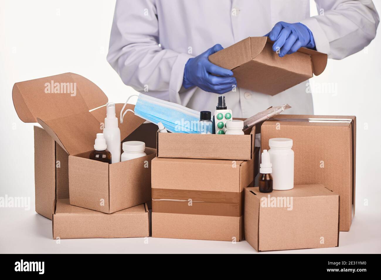 Pharmacist packing ordered medications and supplies into cardboard ...
