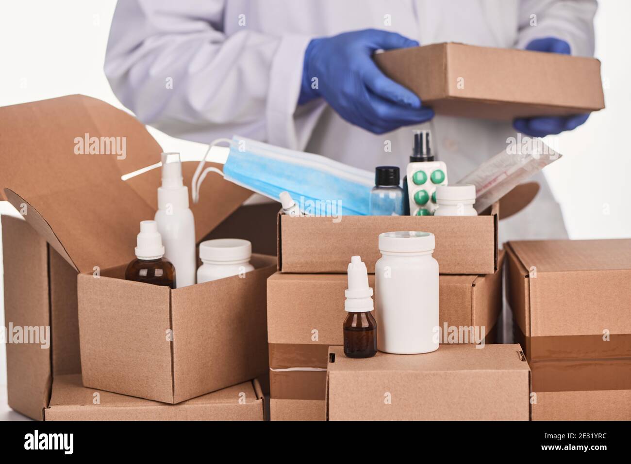 Various medicines being packed into cardboard boxes by a pharmacist ...